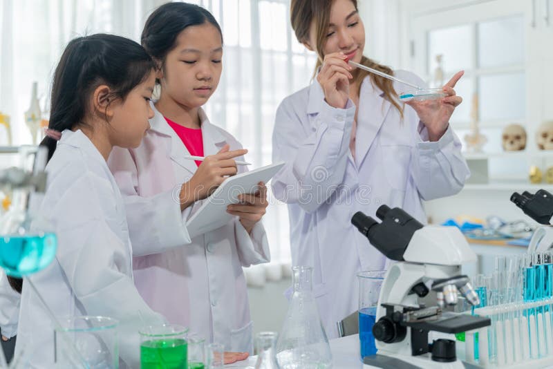 Asian Kid Learning with Scientist in the Laboratory. Physical ...