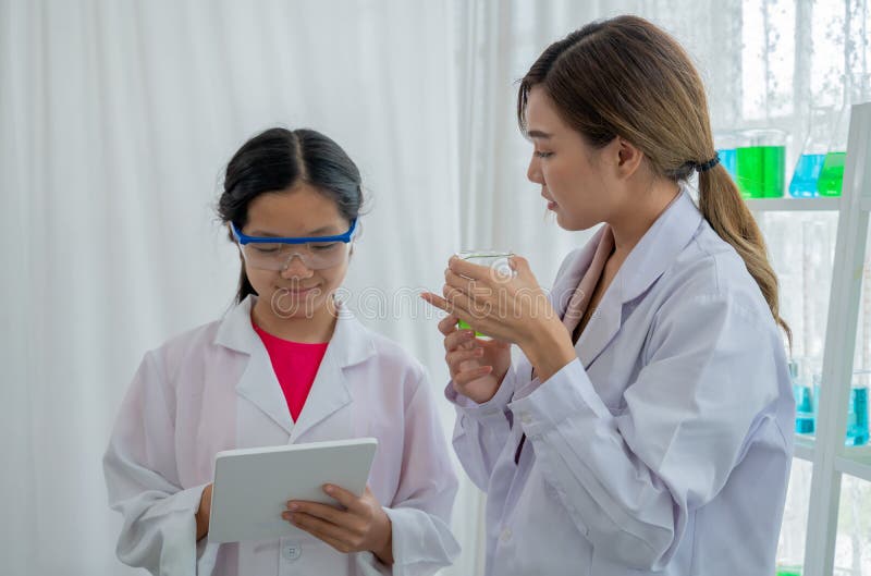 Asian Kid Learning with Scientist in the Laboratory. Physical ...