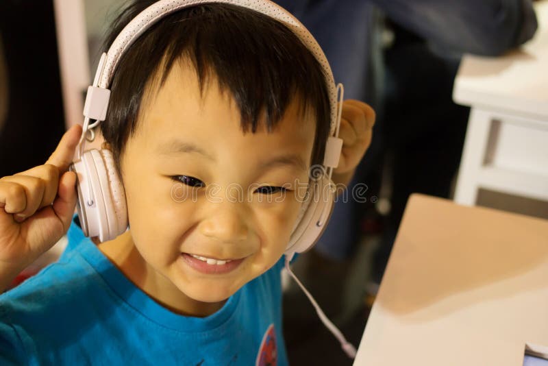 Asian Kid Play Computer Internet Games and Wear Headset Stock Photo ...