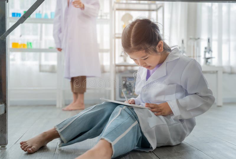 Asian Kid Playing Digital Tablet Under Table during Learning with ...