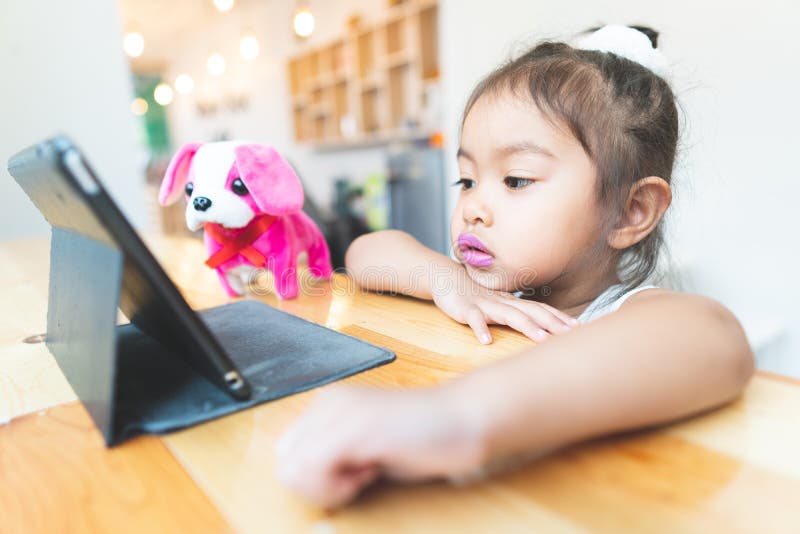 Asian Little Girl Sitting the Tablet is at Home Stock Photo - Image of ...