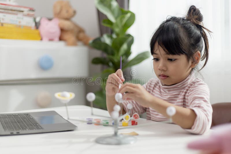 Asian Little Girl Studies the Solar System in Geography Class. Looking ...