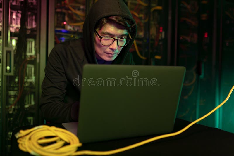 Asian Male Hacker Using a Laptop in Computer Server Room Stock Photo ...