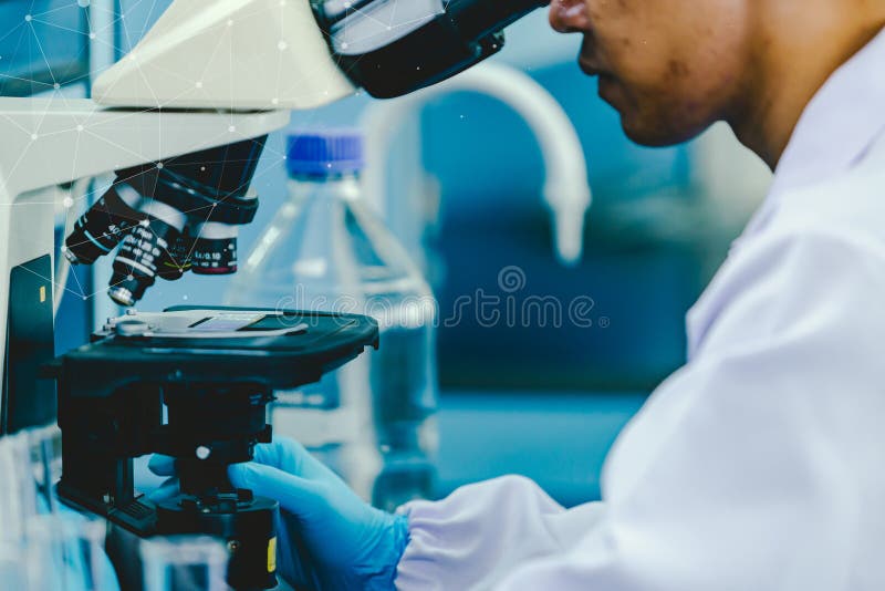 Asian Male Medic in Uniform Working with Microscope Making Analysis at ...