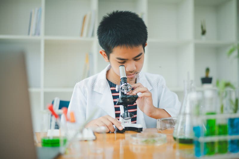 Asian Male Science Students Looking through a Microscope and Tests of ...