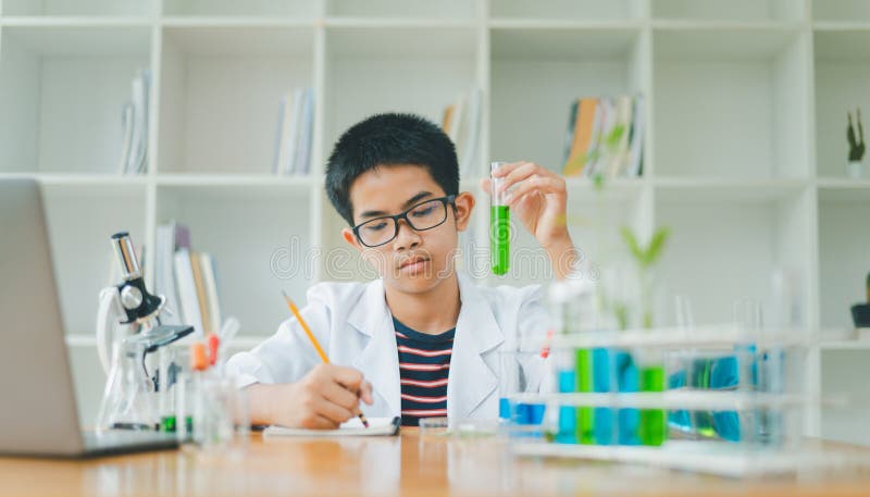 Asian Male Science Students Looking through a Microscope and Tests of ...