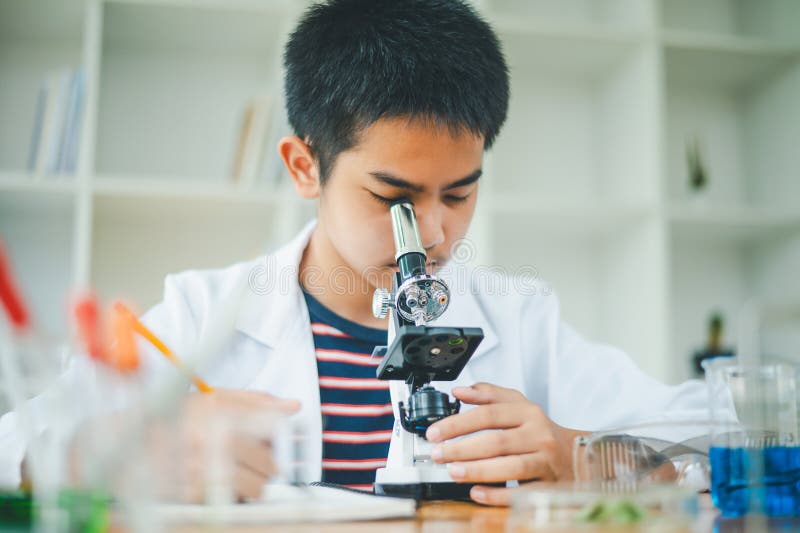 Asian Male Science Students Looking through a Microscope and Tests of ...