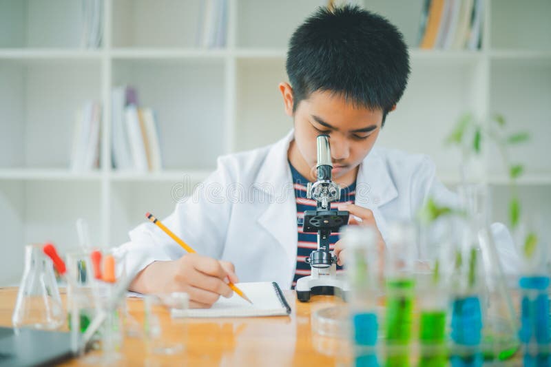 Asian Male Science Students Looking through a Microscope and Tests of ...