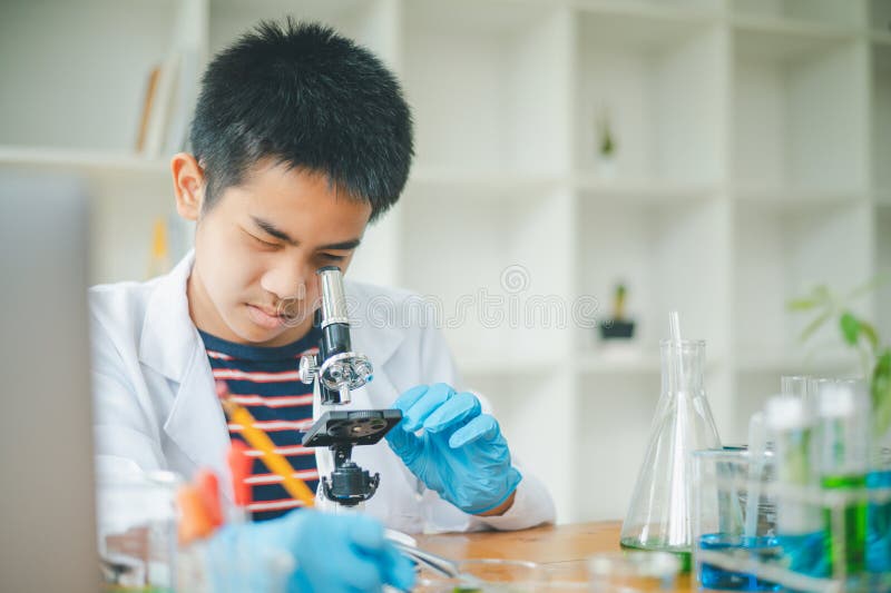 Asian Male Science Students Looking through a Microscope and Tests of ...