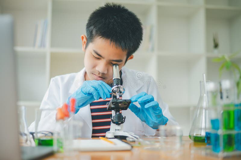Asian Male Science Students Looking through a Microscope and Tests of ...