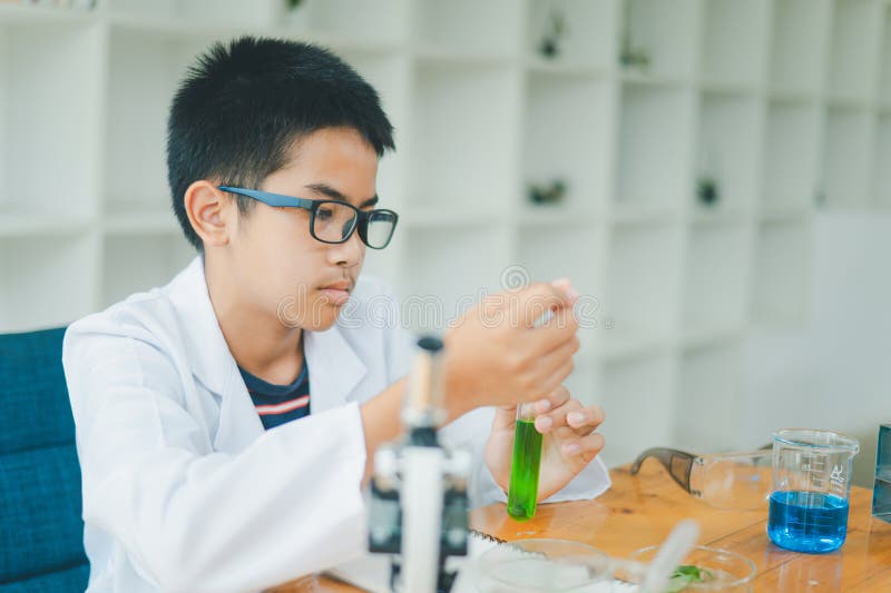 Asian Male Science Students Looking through a Microscope and Tests of ...