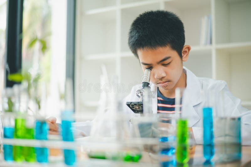 Asian Male Science Students Looking through a Microscope and Tests of ...