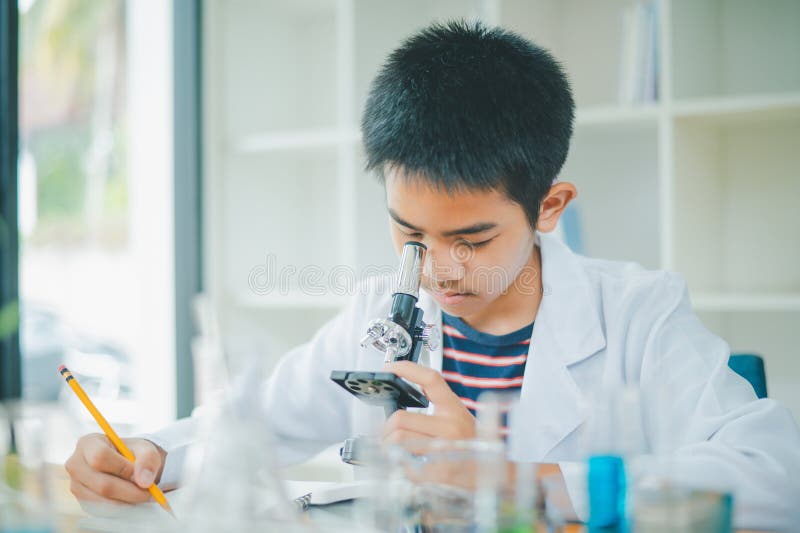 Asian Male Science Students Looking through a Microscope and Tests of ...