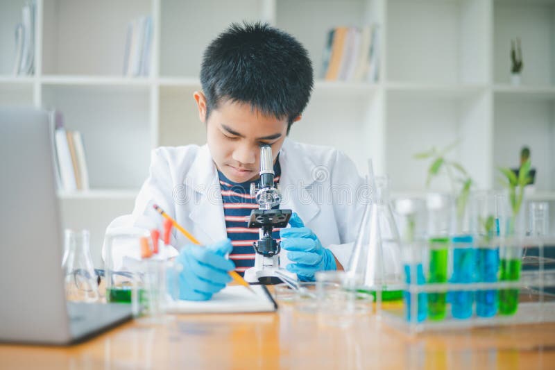Asian Male Science Students Looking through a Microscope and Tests of ...