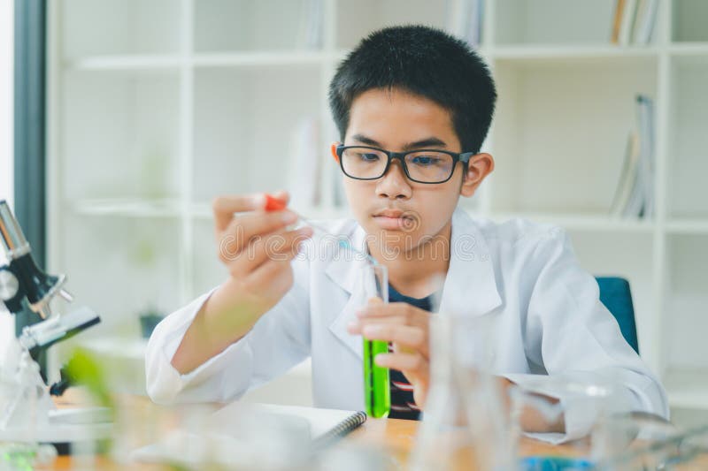 Asian Male Science Students Looking through a Microscope and Tests of ...