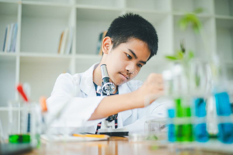 Asian Male Science Students Looking through a Microscope and Tests of ...