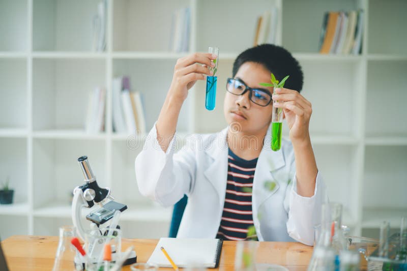 Asian Male Science Students Looking through a Microscope and Tests of ...