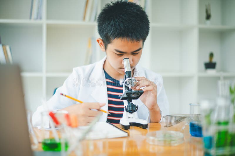 Asian Male Science Students Looking through a Microscope and Tests of ...