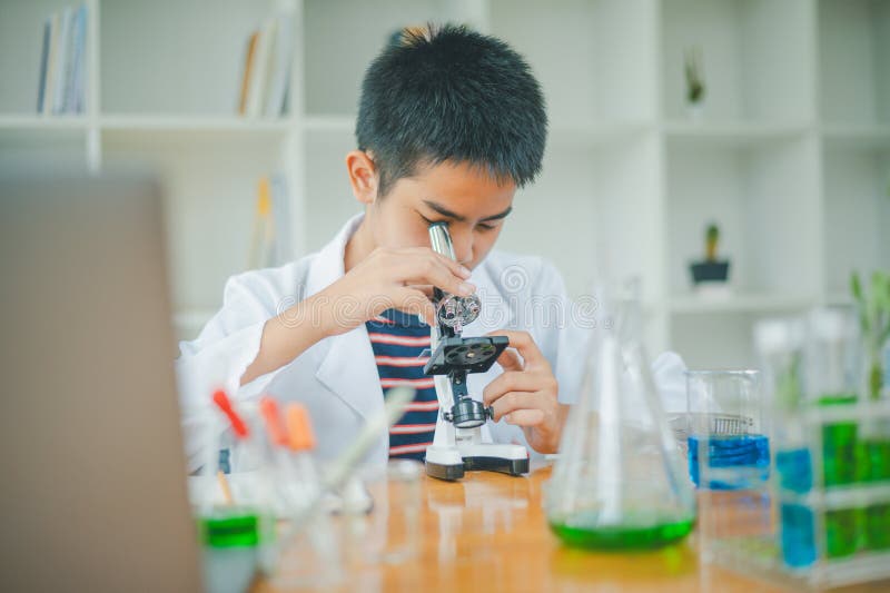 Asian Male Science Students Looking through a Microscope and Tests of ...