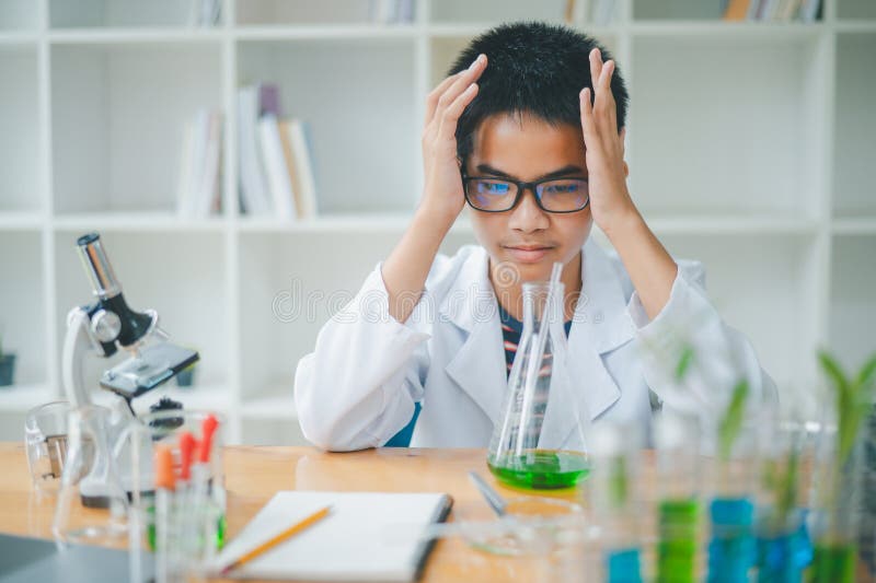 Asian Male Science Students Looking through a Microscope and Tests of ...