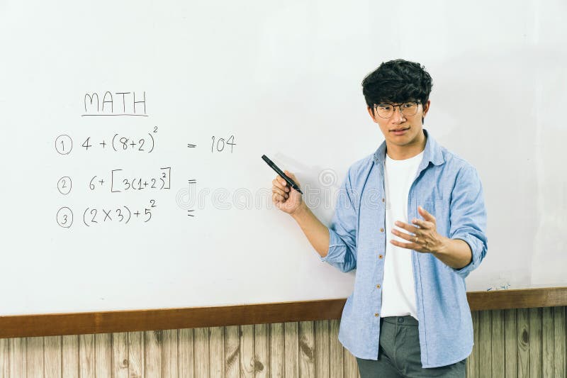Asian Male Teacher is Teaching Students at the Classroom while Pointing ...