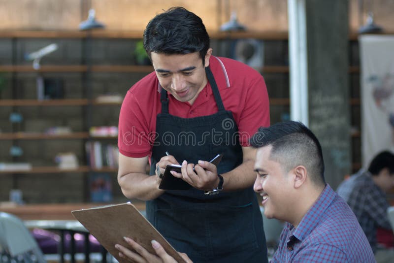Asian Male Waiter Write Orders from Costumers at Cafe in Background ...