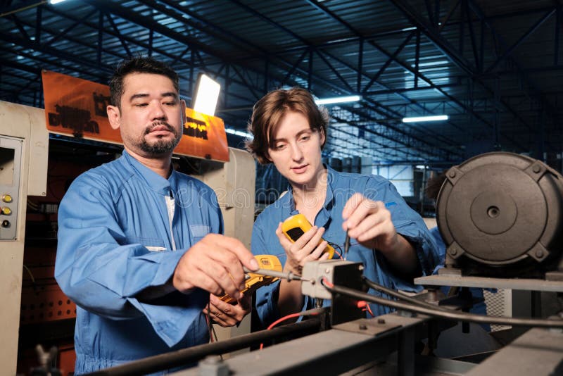 Two Professional Engineers Inspect Machines` Electric Systems at the ...