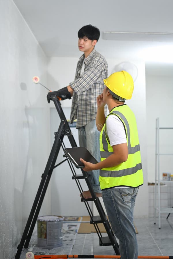 Asian Male Worker Applying Paint Under the Guidance of Project Manager ...