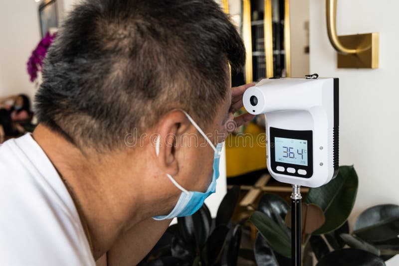 Asian Man Checking Forehead Temperature Using Infrared Thermometer ...
