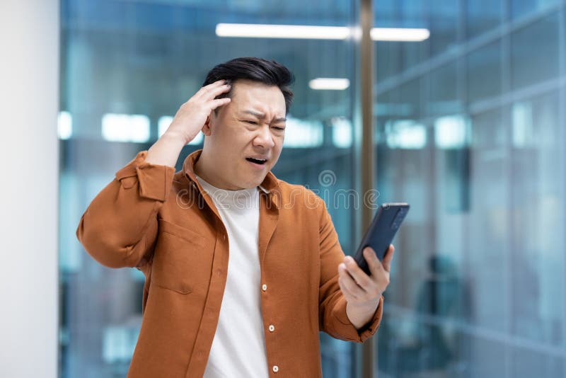 Asian Man Confused while Using Smartphone for Communication or Browsing ...