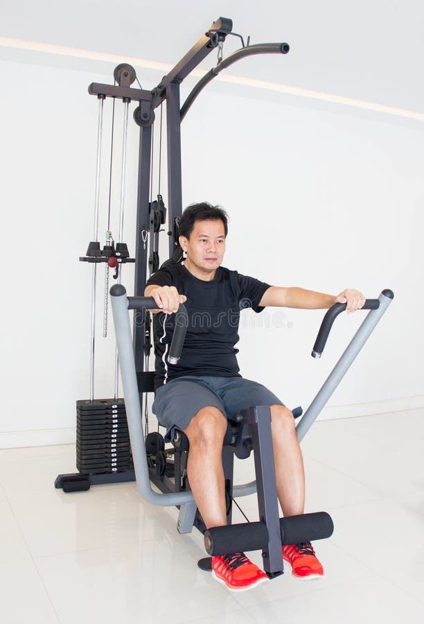 Asian Man Doing Exercise on Fitness Machine. Stock Photo - Image of ...