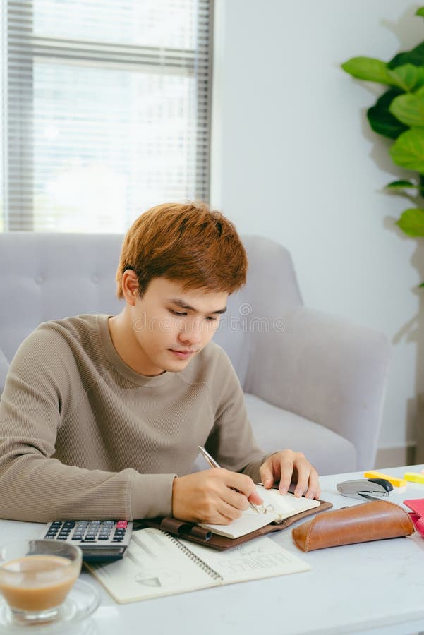 Asian Man Doing Finances and Calculate about Cost at Home Office Stock ...