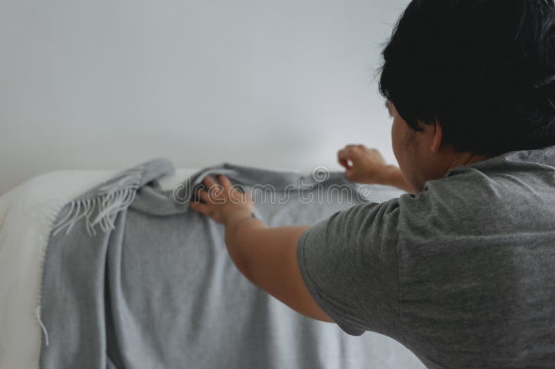 Man is Doing His House Work, Covering the Sofa with Grey Sheet. Stock ...