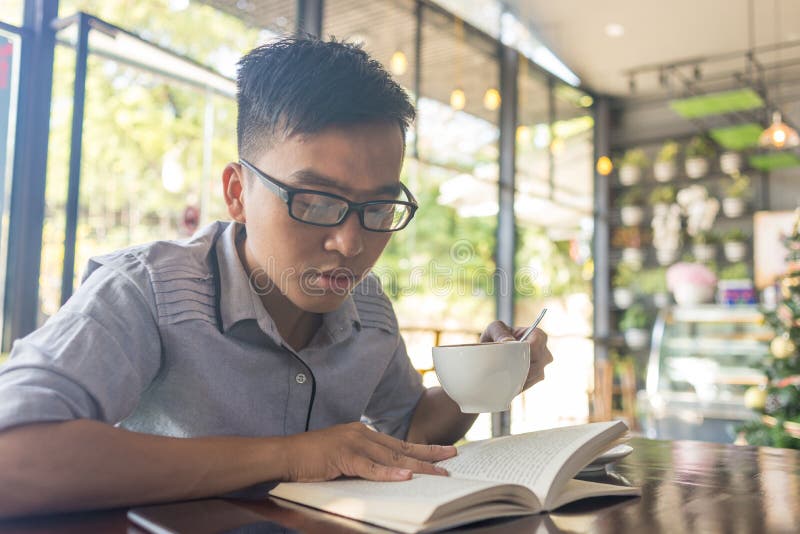 Asian Man Drinking Coffee and Reading Books Stock Image - Image of ...