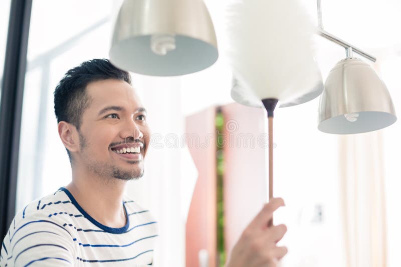 Man dusting his apartment stock photo. Image of dust - 12399872