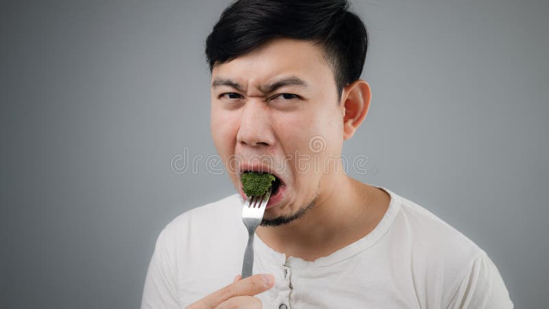 An Asian Man Eats Broccoli. Stock Image - Image of face, food: 57158943