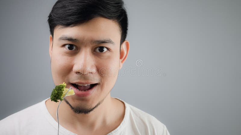 An Asian Man Eats Broccoli. Stock Image - Image of looking, holding ...