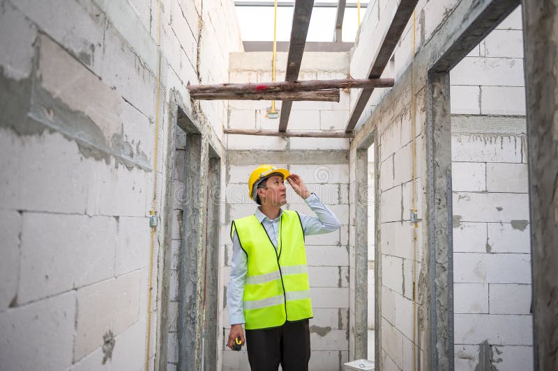 Asian Man Engineer is Putting a Protective Helmet on His Head Stock ...