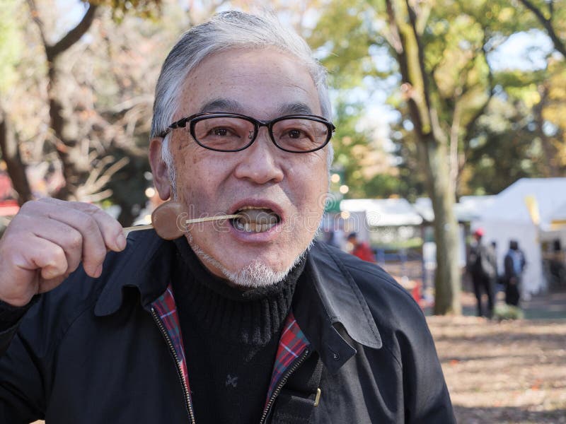 An Asian Man in Glasses Eating Dango Stock Image - Image of plant ...