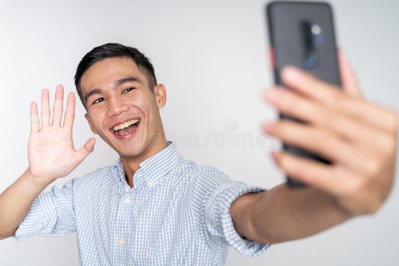 Asian Man Greeting while Making a Phone Video Call Using His Smartphone ...