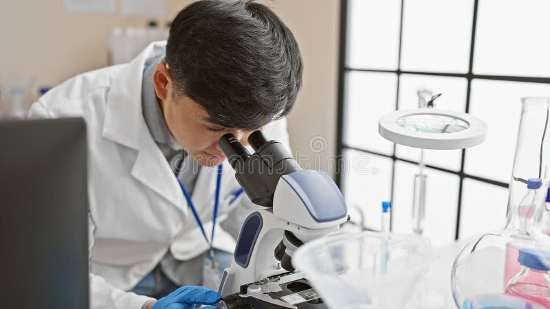 Asian Man in Lab Analyzing Samples Using Microscope in Scientific ...