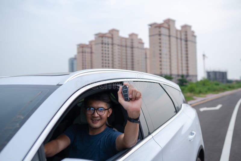 Asian Man Shows Off the Key of an Innovative Electric Car Stock Photo ...