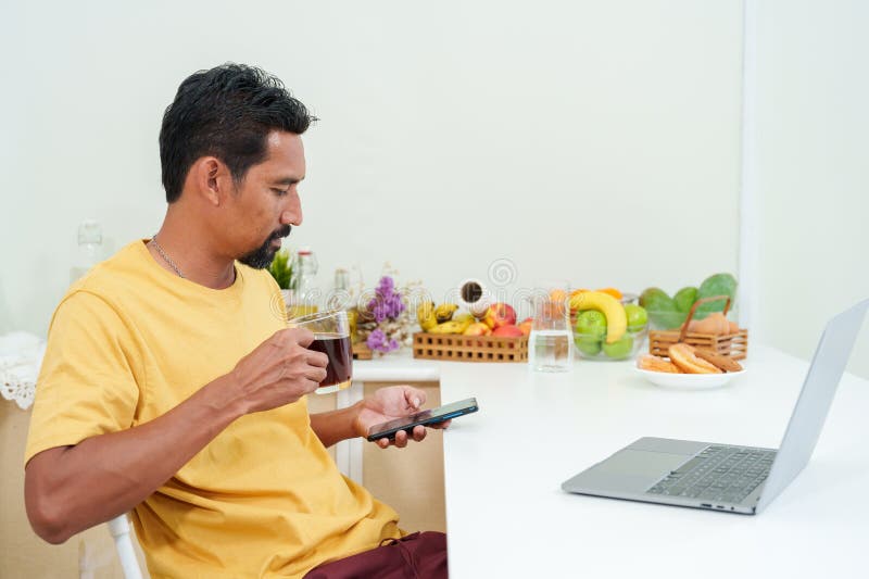 Asian Man Sitting Working in at Home, There is Laptop Computer on Table ...