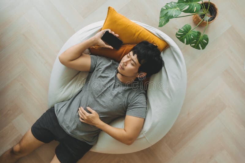 Man Sleep Over the Phone on the Bean Bag Sofa, Taking a Nap in the ...
