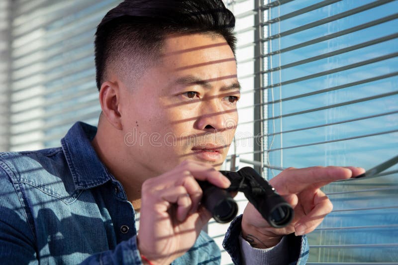 Asian Man Spying through Window Blinds with Binoculars Stock Image ...