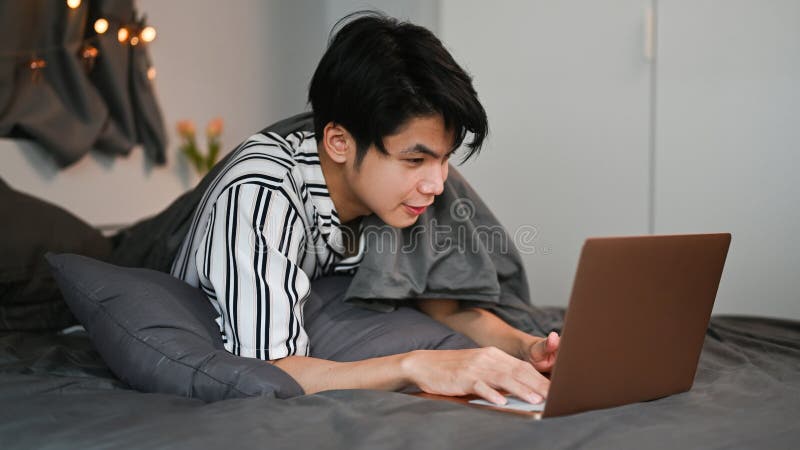 Man Surfing Internet with Computer Laptop on Bed at Night. Stock Image ...