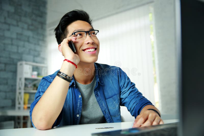 Asian Man Talking on the Phone at His Workplace Stock Photo - Image of ...