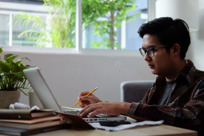 Asian Man Using Laptop Computer and Counting Taxes or House ...