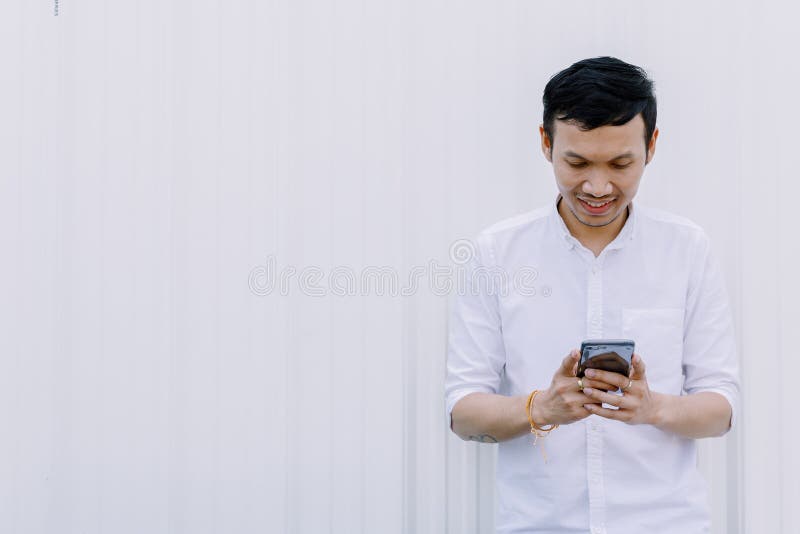 Asian Man Using a Mobile Phone Smile with White Walls Stock Photo ...