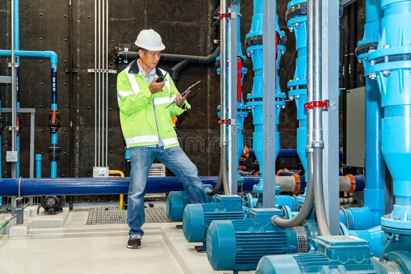Asian Man Worker in Protective Uniform and with Hardhat Using Tablet ...